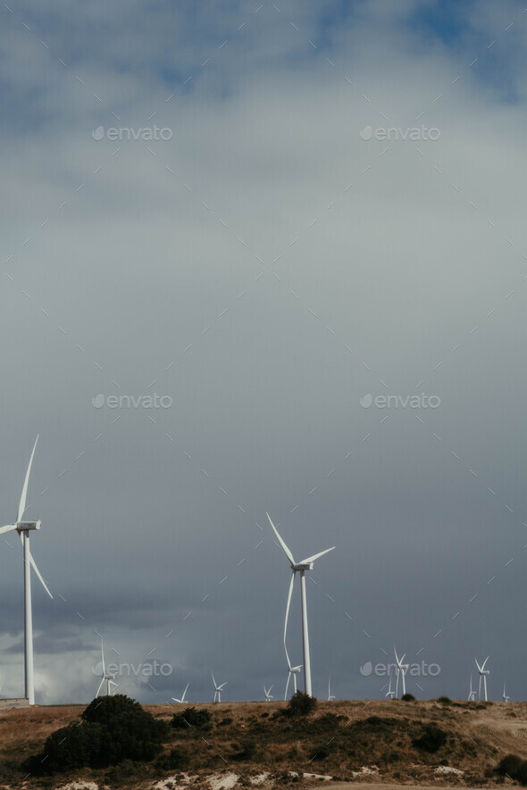 Vertical shot of wind turbines spinning on a valley Stock Photo by ...