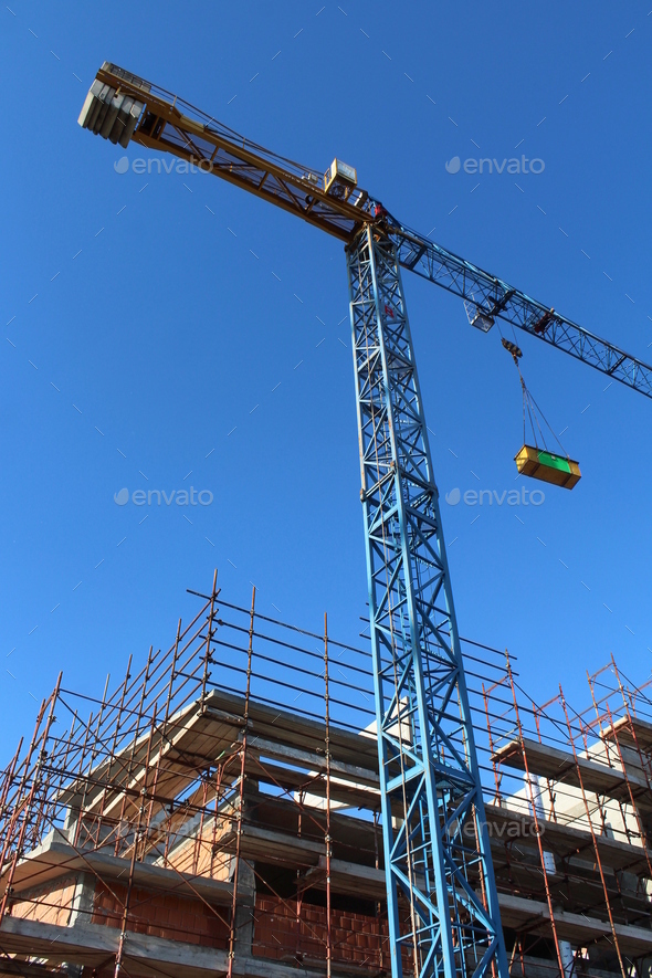 View of construction site with tall tower crance with a blue sky on a ...