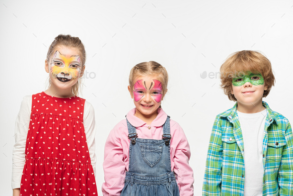 smiling friends with colorful face paintings looking at camera isolated ...