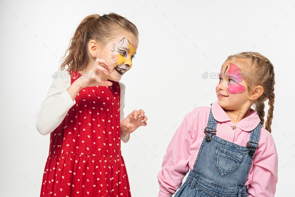 cheerful kid with cat muzzle painting on face scaring friend isolated ...