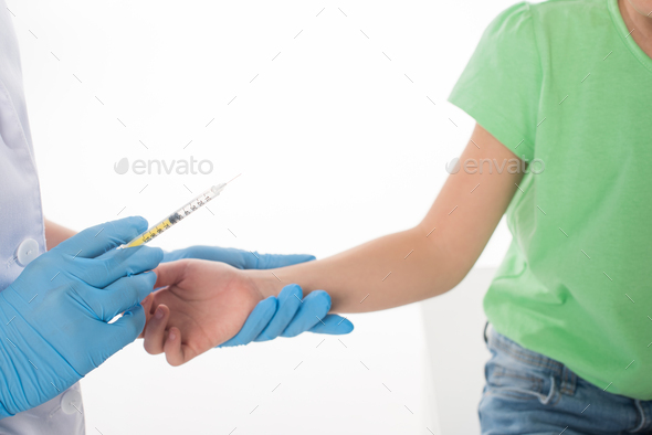 Cropped view of pediatrician doing injection with vaccine to kid ...