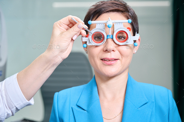 Vision specialist conducting monocular subjective refraction in female ...