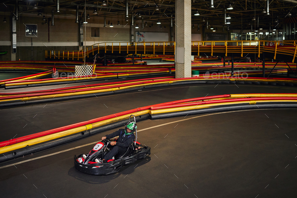 speed drive, african american man in go-kart on circuit, racing inside ...