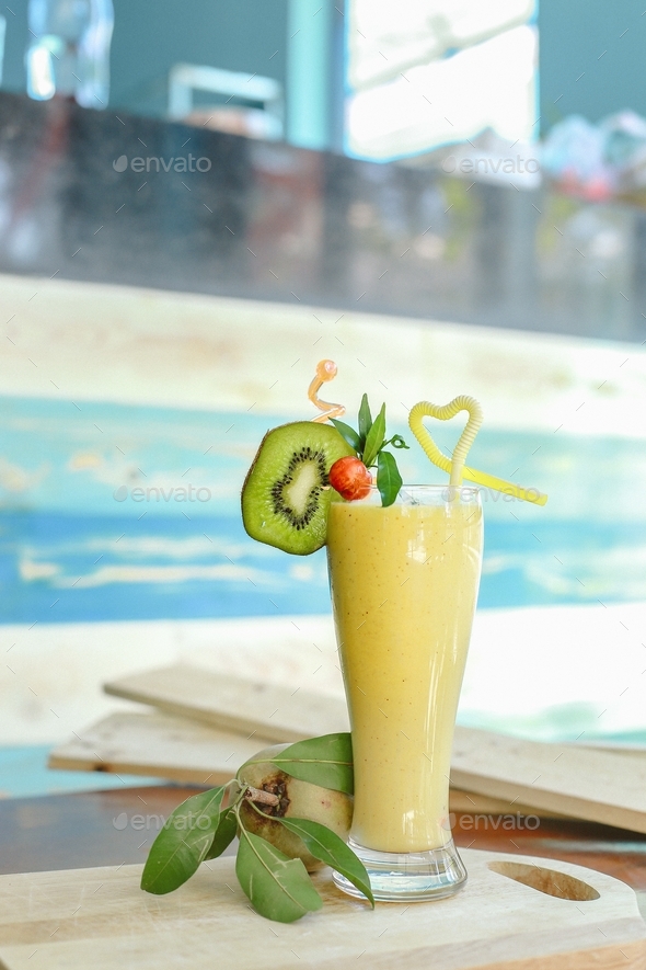 Vertical picture of a delicious fruit smoothie with kiwis on a table ...