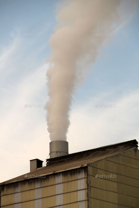 Vertical shot of a smoke coming out from a chimney of a factory Stock ...