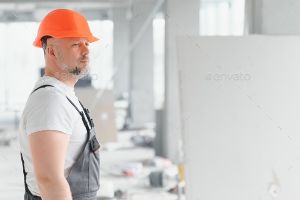 Man Builder. Architect is standing in building. Portrait of thinking ...