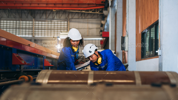 Industrial worker inspecting and check up machine at factory machines ...