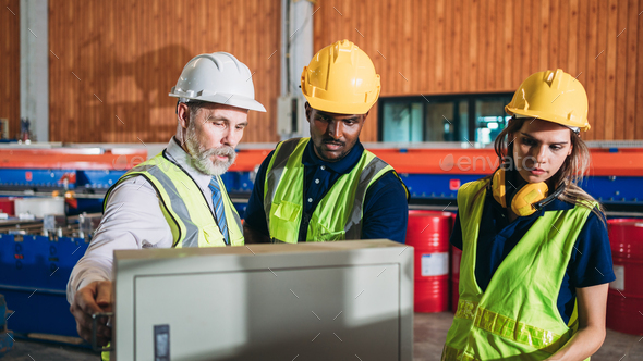 Industrial worker inspecting and check up machine at factory machines ...