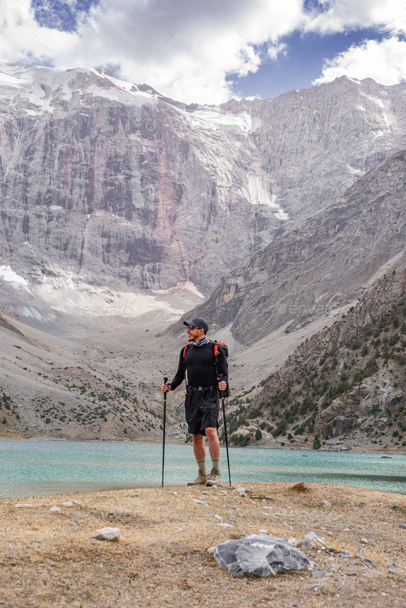 Man hiker exploring mountains lake in Tajikistan Stock Photo by ...