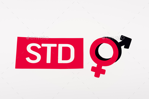 top view of gender symbols near paper with std lettering isolated on ...