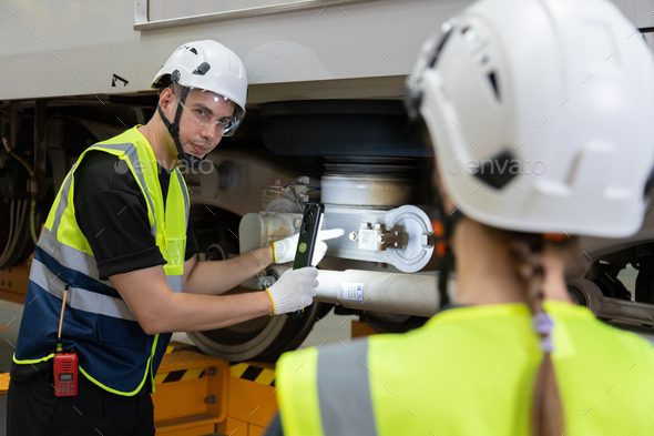 Two professional engineers check mechanical check undercarriage of ...