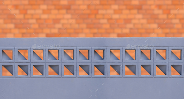 Gray painted concrete fence wall with ventilation blocks with blurred ...