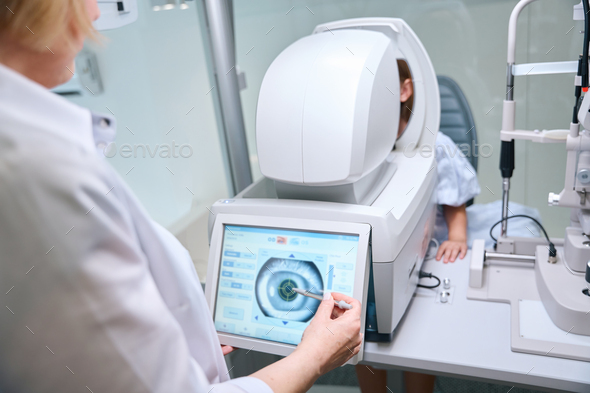 Ophthalmologist taking automated objective refraction measurement in ...