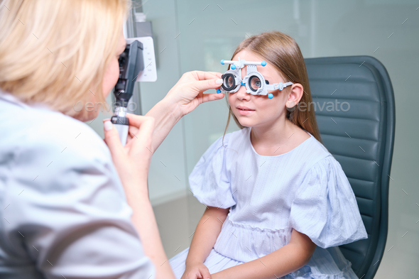 Experienced female optometrist carrying out dynamic retinoscopy on ...