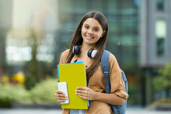 Cheerful beautiful woman student posing at university campus, copy ...