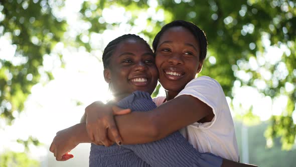 Two Happy Female African American Friends Hugging Looking Away Smiling ...