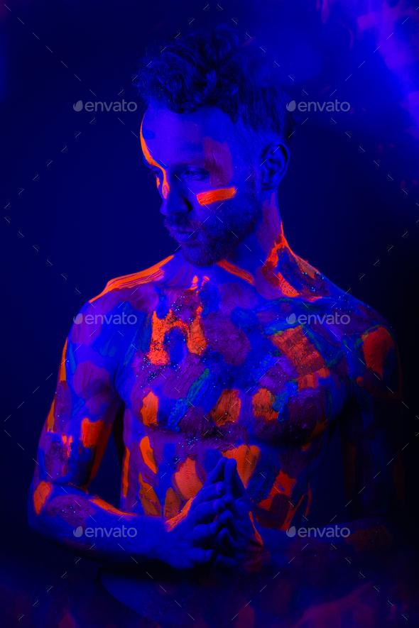 Portrait of a man with ultraviolet makeup and neon light in cyberpunk ...