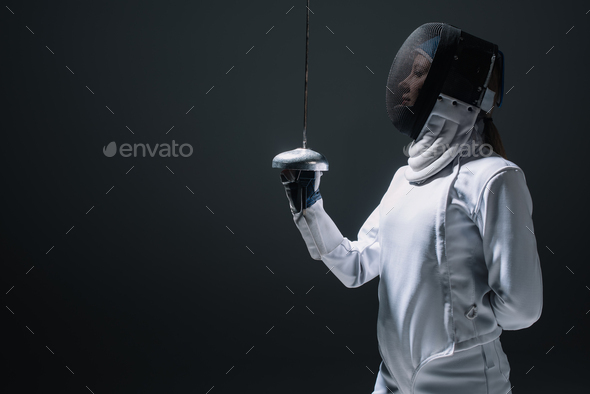 Side view of fencer in fencing mask holding rapier isolated on black ...