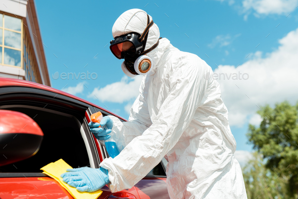 specialist in hazmat suit and respirator cleaning car with antiseptic ...
