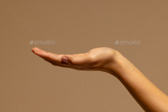 Upturned hand of biracial woman on brown background with copy space ...