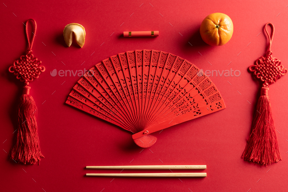 Composition of traditional chinese fan and decorations on red ...