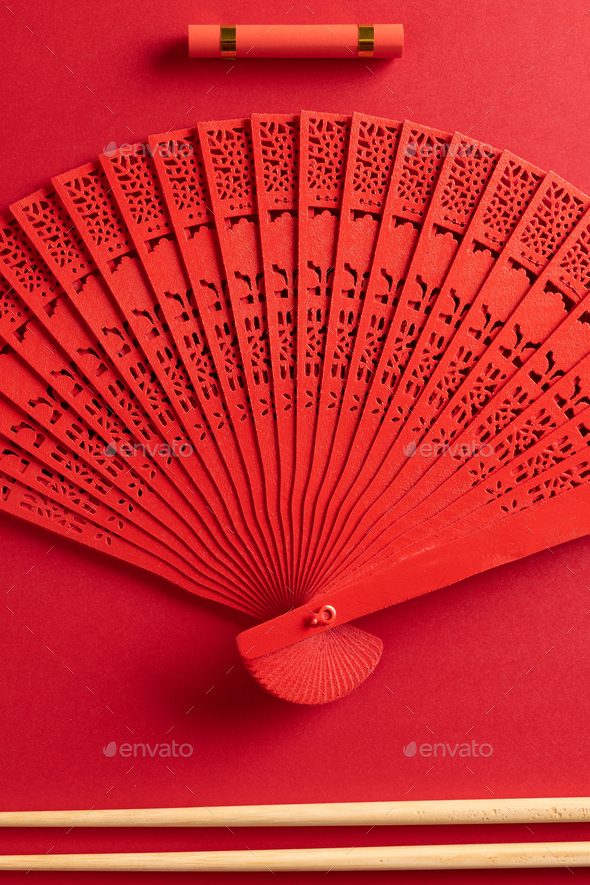 Composition of traditional chinese fan and decorations on red ...