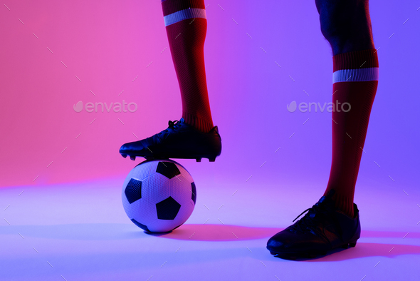 African american male soccer player with football over neon pink ...
