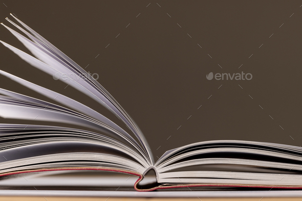 Image of open book lying on brown background Stock Photo by Wavebreakmedia