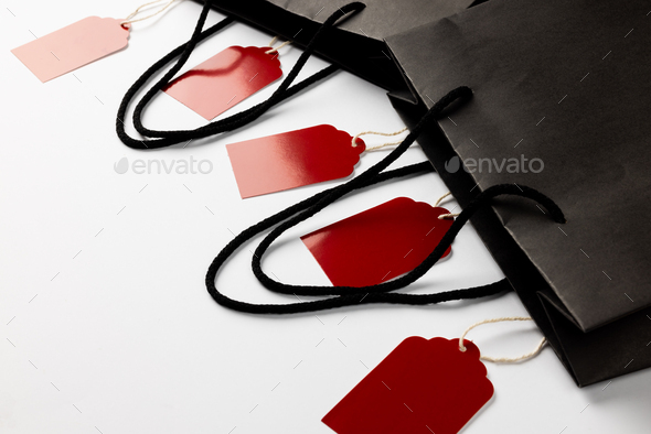Composition of gift tags and bags with copy space on white background ...