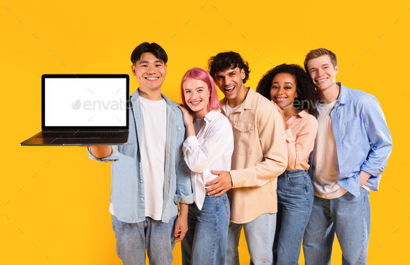 Five multiracial friends holding laptop showing blank computer screen ...