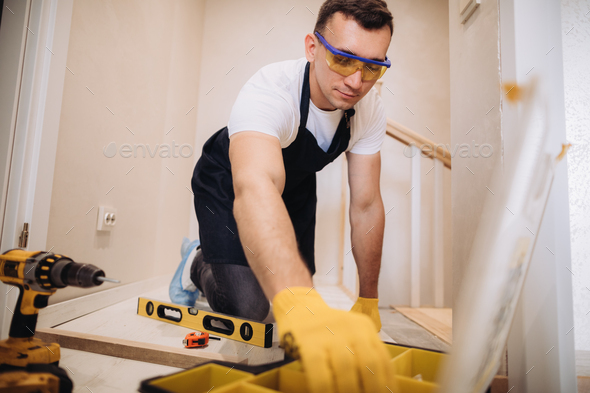 Maintenance man fixing a new floor Stock Photo by dmytros9 | PhotoDune