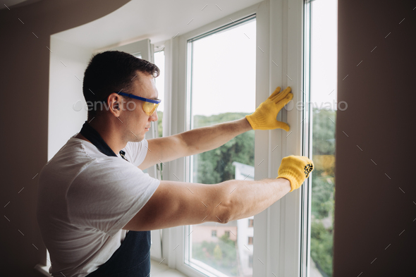Maintenance man fixing windows with instruments Stock Photo by dmytros9