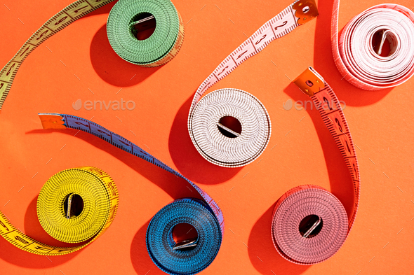 colorful measuring tapes top view on bright red background Stock Photo ...