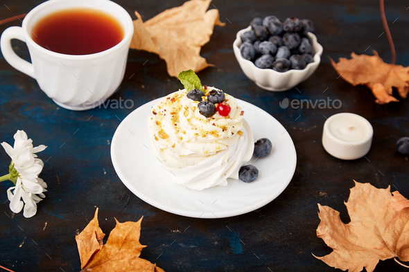 Traditional Pavlova Dessert with Tea Cup and blueberry. Autumn tea time ...