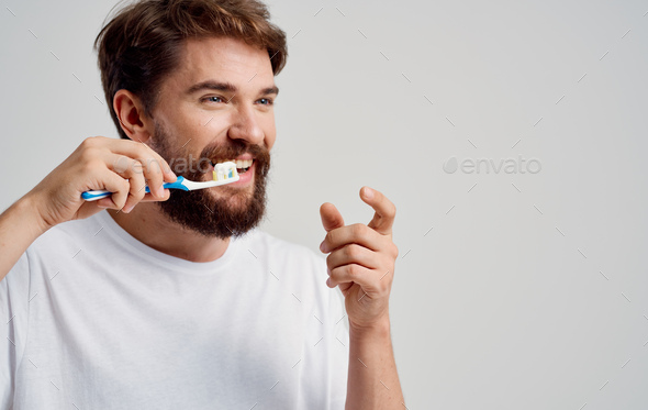 handsome man brushing teeth oral care light background morning ...