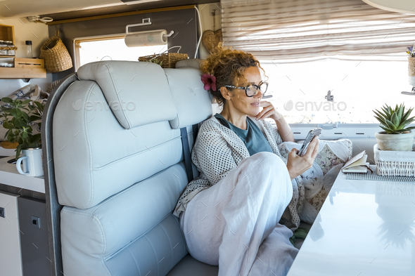 Adult woman relaxing inside a modern luxury camper van rv vehicle ...