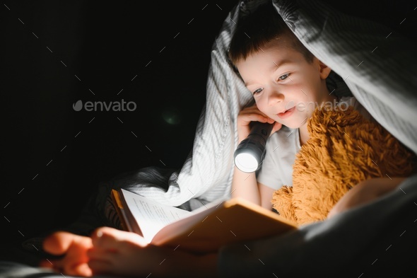 Child reading book in bed. Kids read at night. Little boy with fairy ...