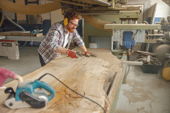 Carpenter is cleaning saw from sawdust with air compressor working in ...