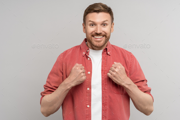 Excited overjoyed man rejoicing at unexpected result, holding fists ...