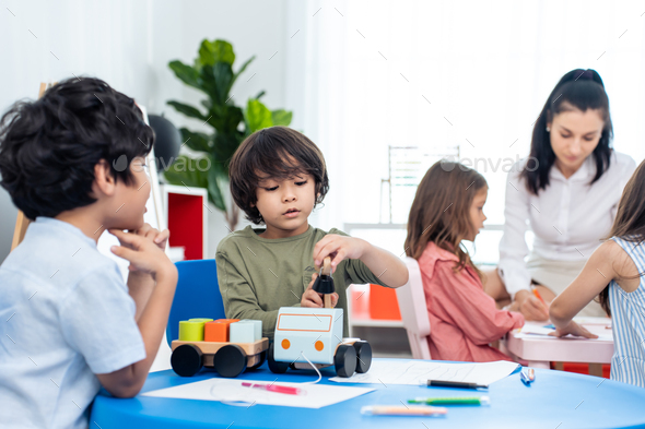 Caucasian beautiful woman teacher teaching a lesson to kid at school ...