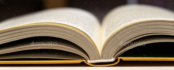 Open book close up. One book is yellow. Stock Photo by anatolikFOTO