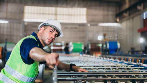 Industrial worker inspecting and check up machine at factory machines ...