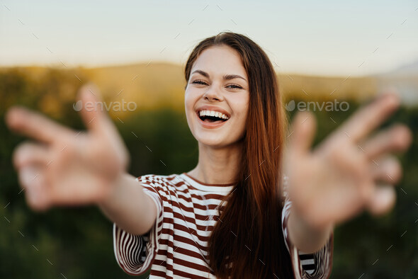 Woman smiling while looking at the camera and pulling her hands to the ...
