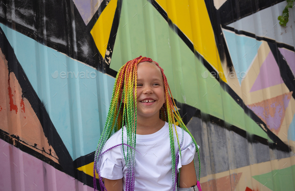 girl with multi-colored african braids on the background of a colorful ...