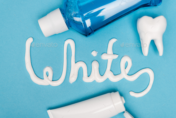 Top view of white lettering from toothpaste, tooth model and mouthwash ...
