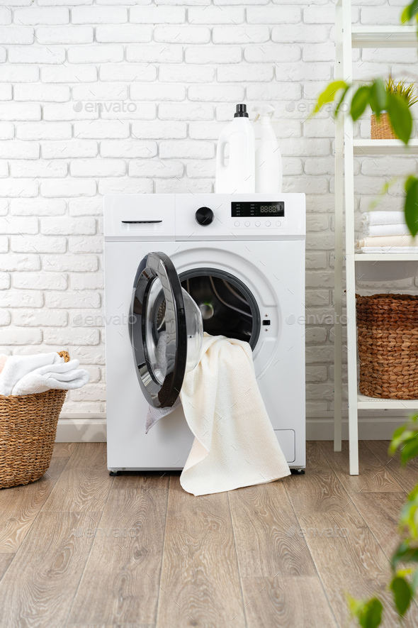 Washing machine and basket in a laundry room Stock Photo by FabrikaPhoto