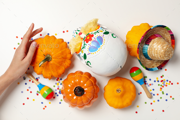 Mexican skull, pumpkins, sombrero, maracas and hand on white background ...
