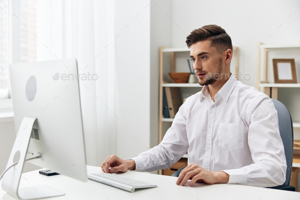 manager sitting at a desk in front of a computer with a keyboard ...