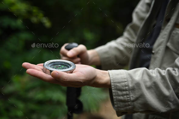 Male hiker using compass for directions in the forest, enjoying his ...