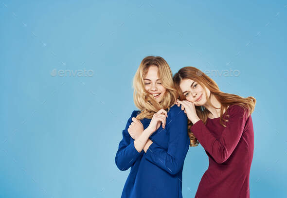 two women in dresses hugs lifestyle blue background Stock Photo by ...